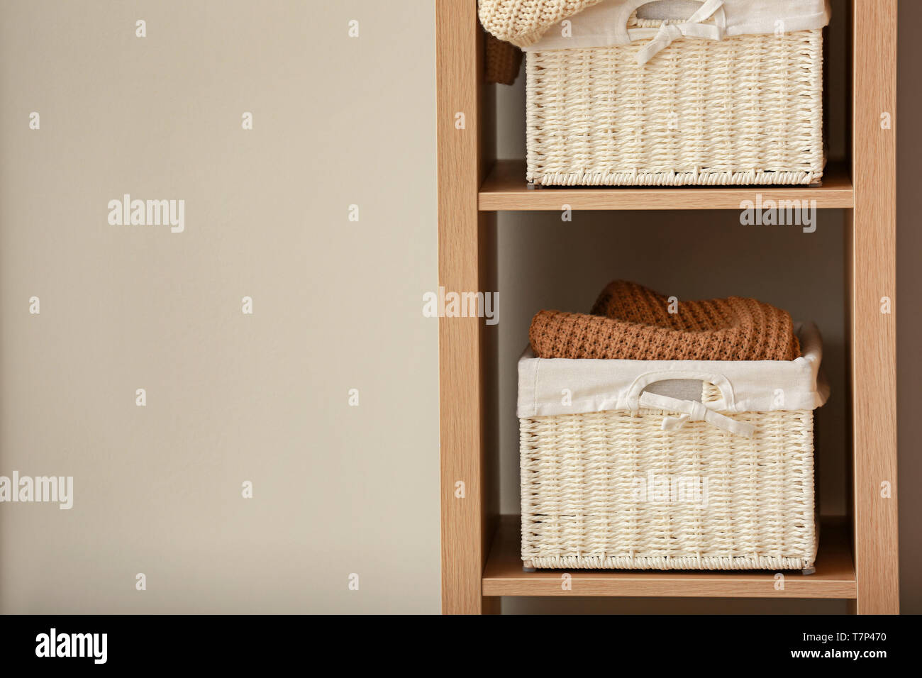 Shelf unit with baskets on light background Stock Photo - Alamy