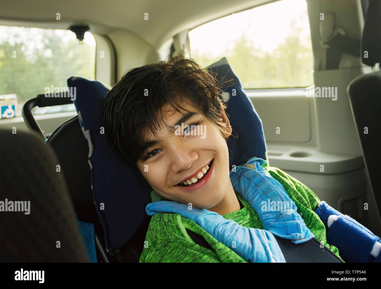 Smiling twelve year old biracial disabled boy in handicap vehicle ...