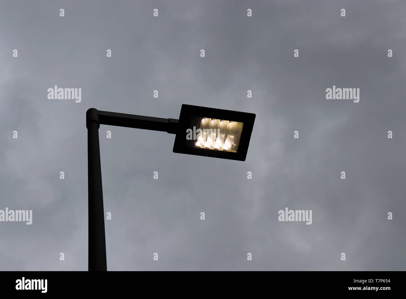 LED street lamp post glowing on dark cloudy sky background. Led lights ...