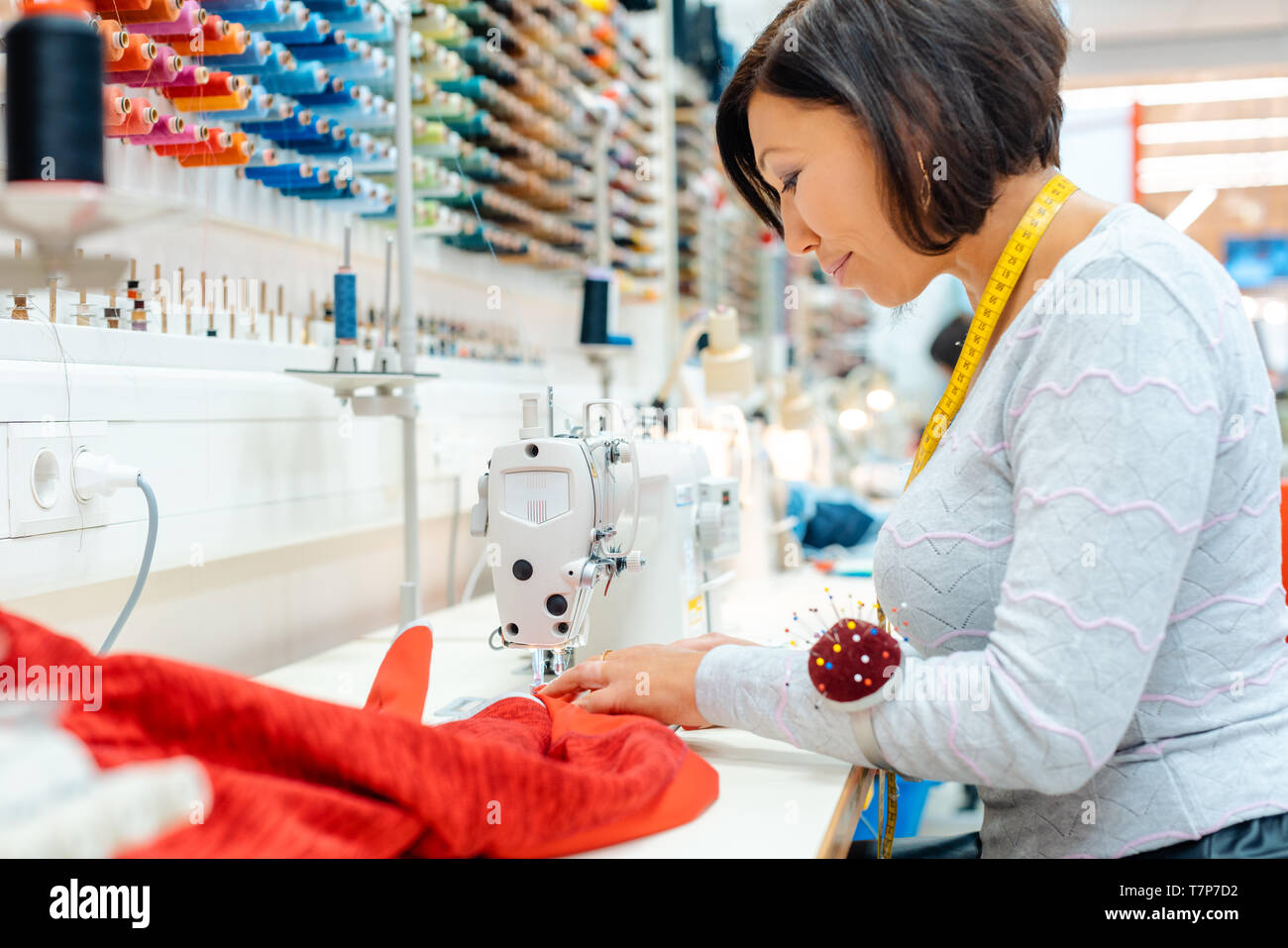 Seamstress working in her studio sewing clothes Stock Photo - Alamy