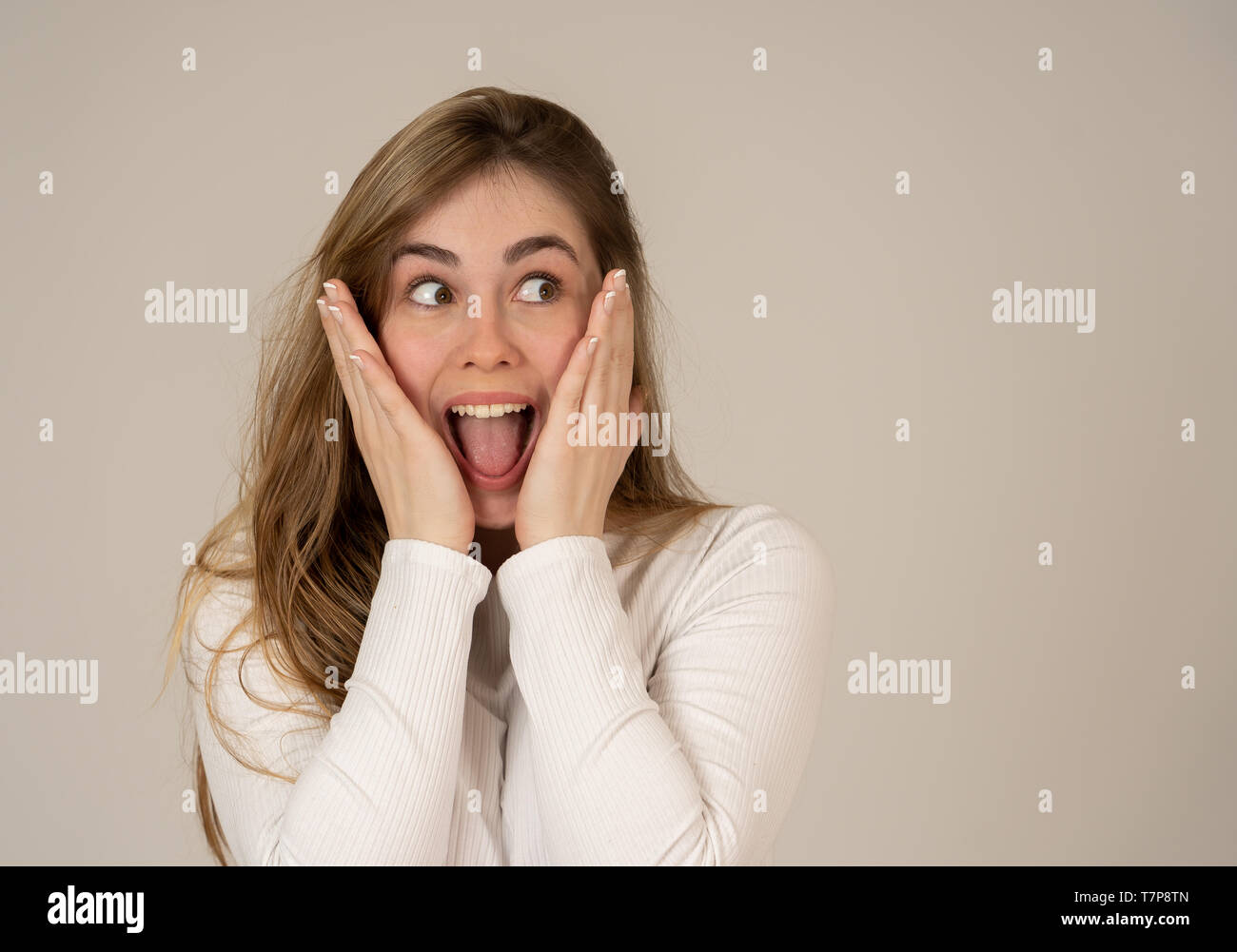 Beautiful young blonde teenager woman with happy face making surprised ...