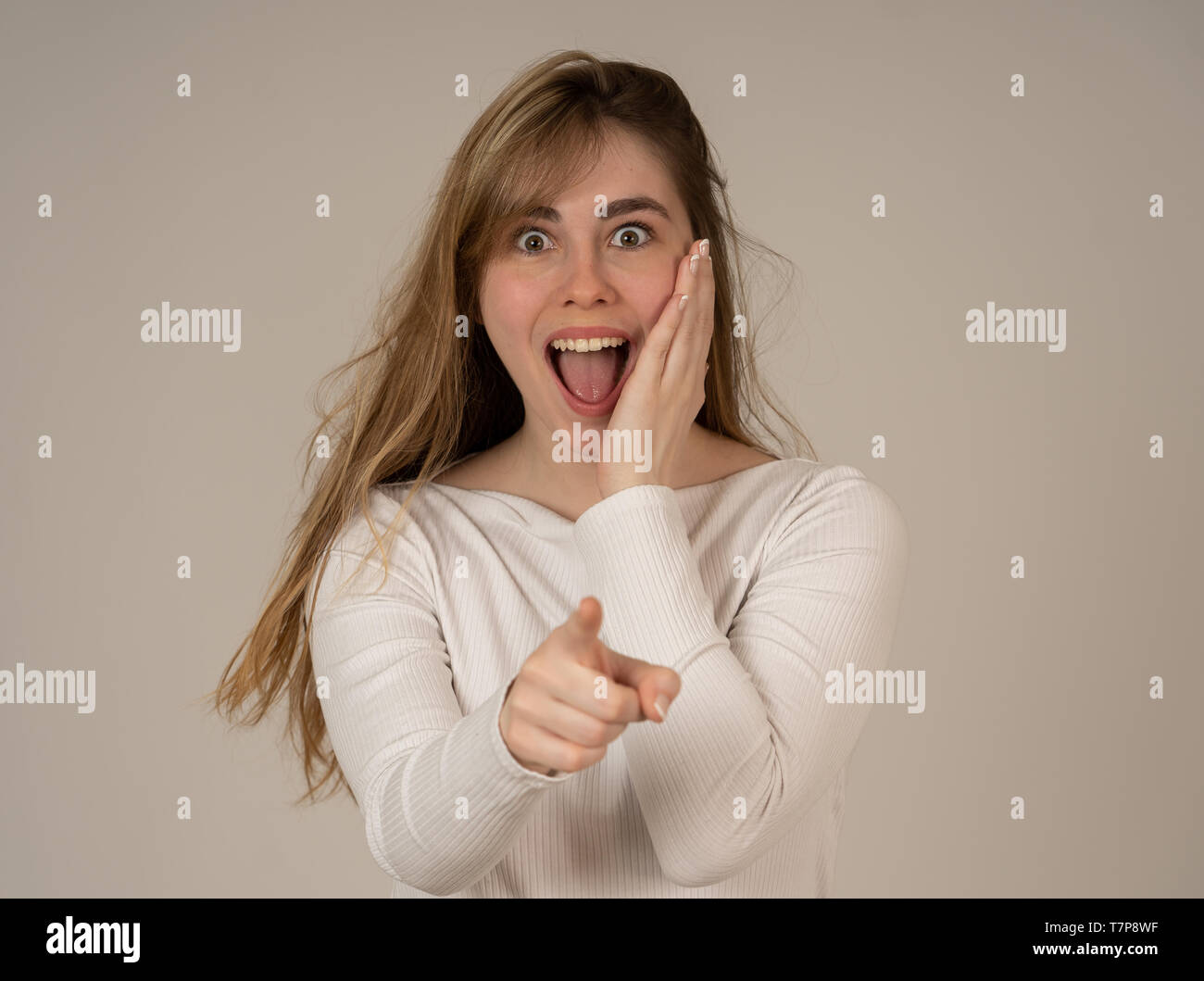 Beautiful young blonde teenager woman with happy face making surprised ...