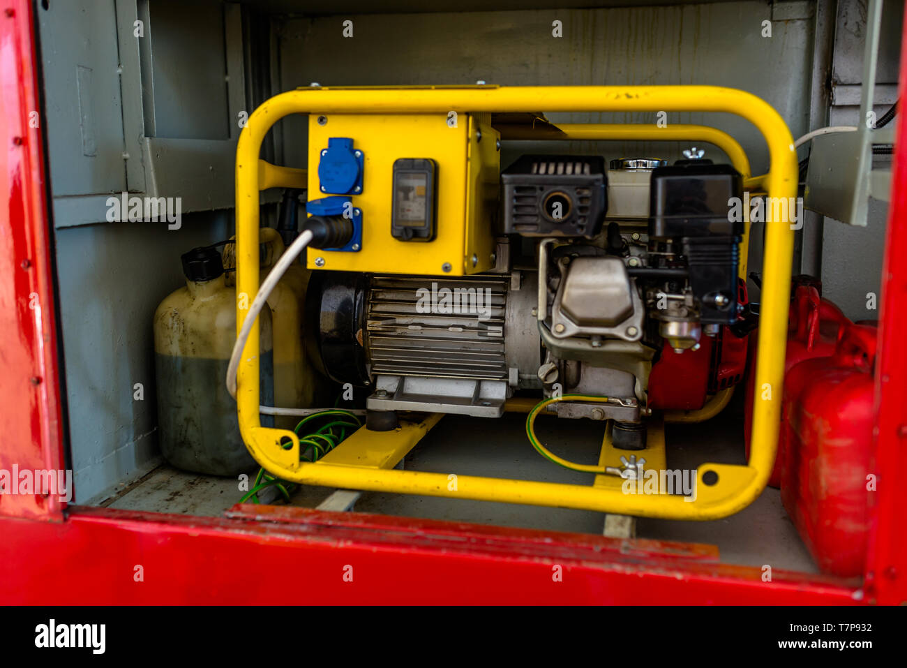 Power generator for gasoline in a yellow housing standing in the glove ...