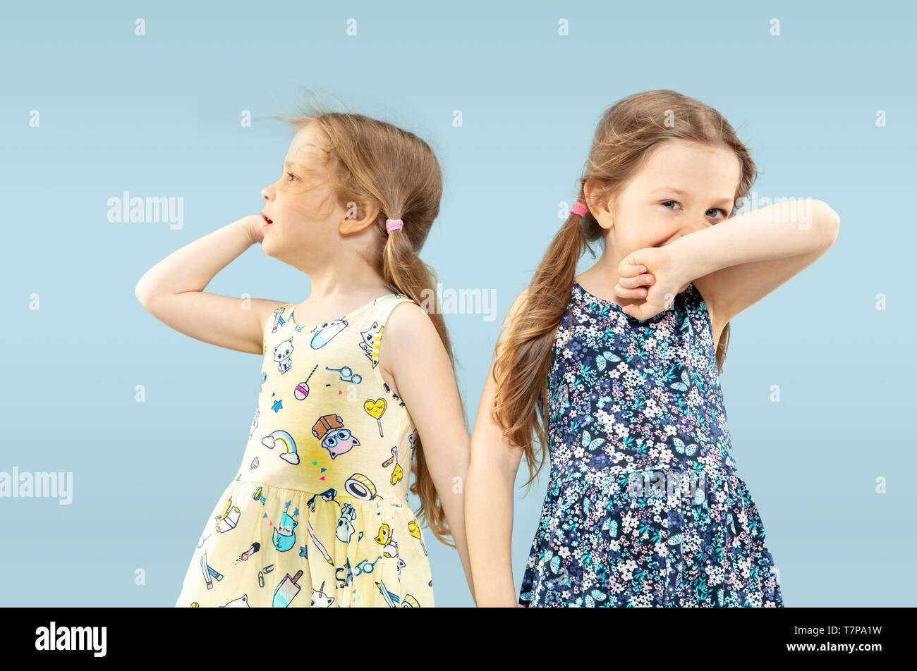Beautiful emotional little girls isolated on blue background. Half ...
