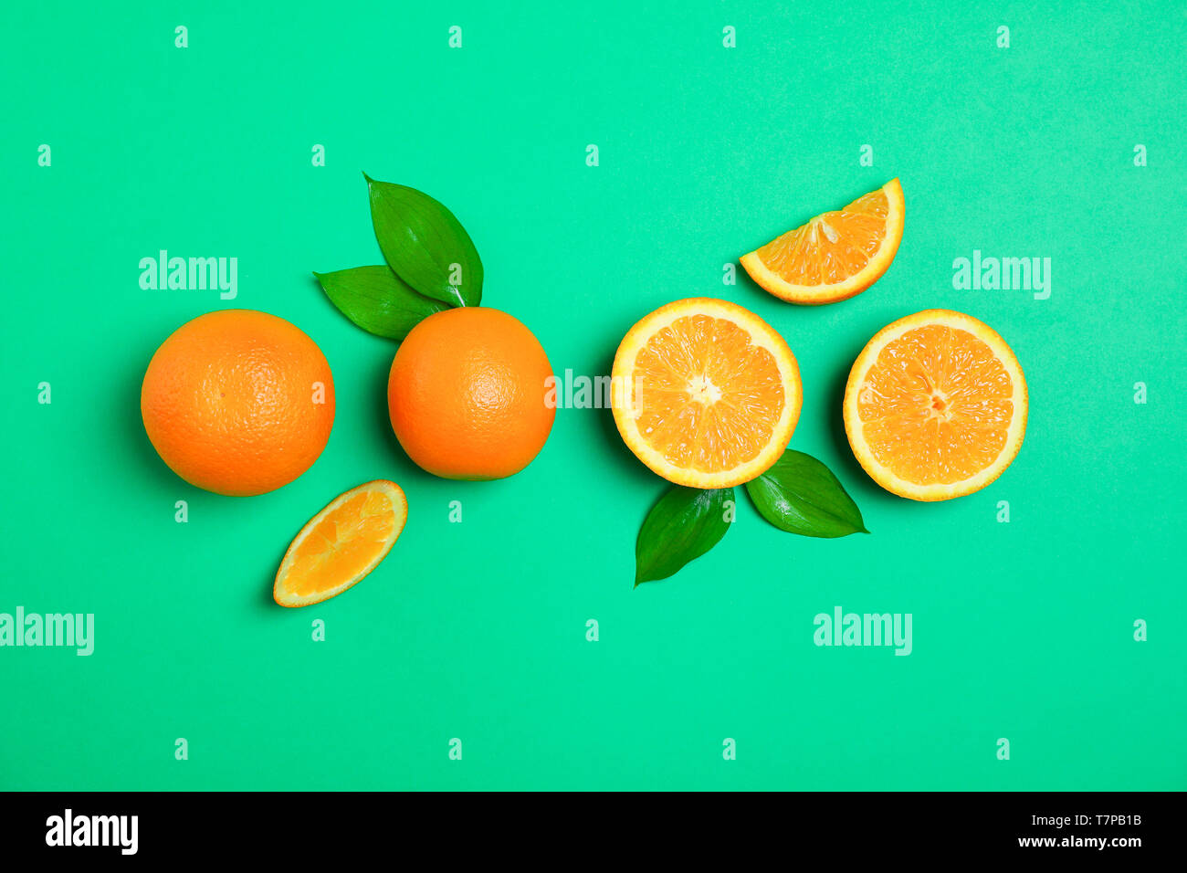 Flat lay composition with oranges and leaves on color background. Space ...