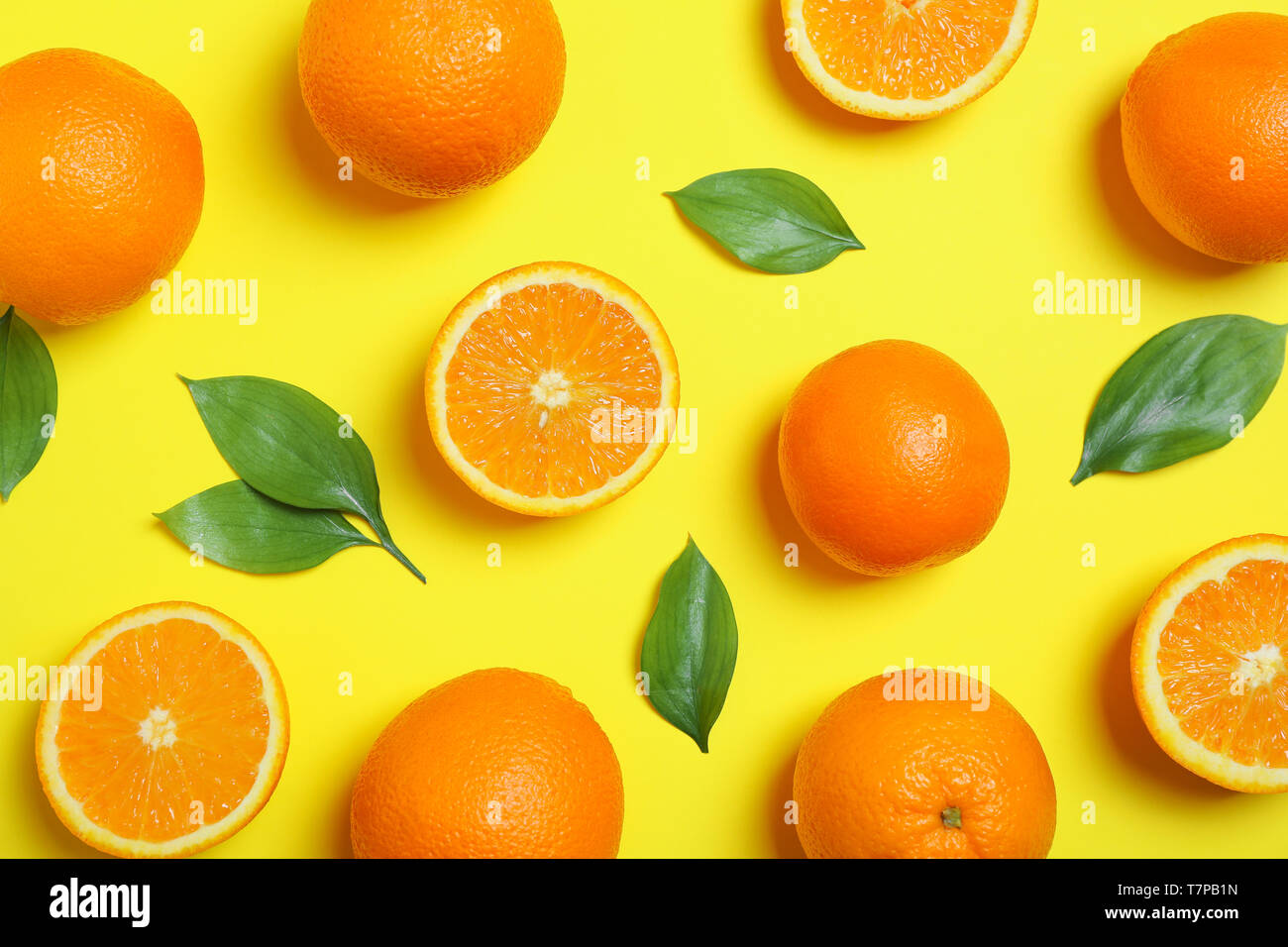 Flat lay composition with oranges and leaves on yellow background ...