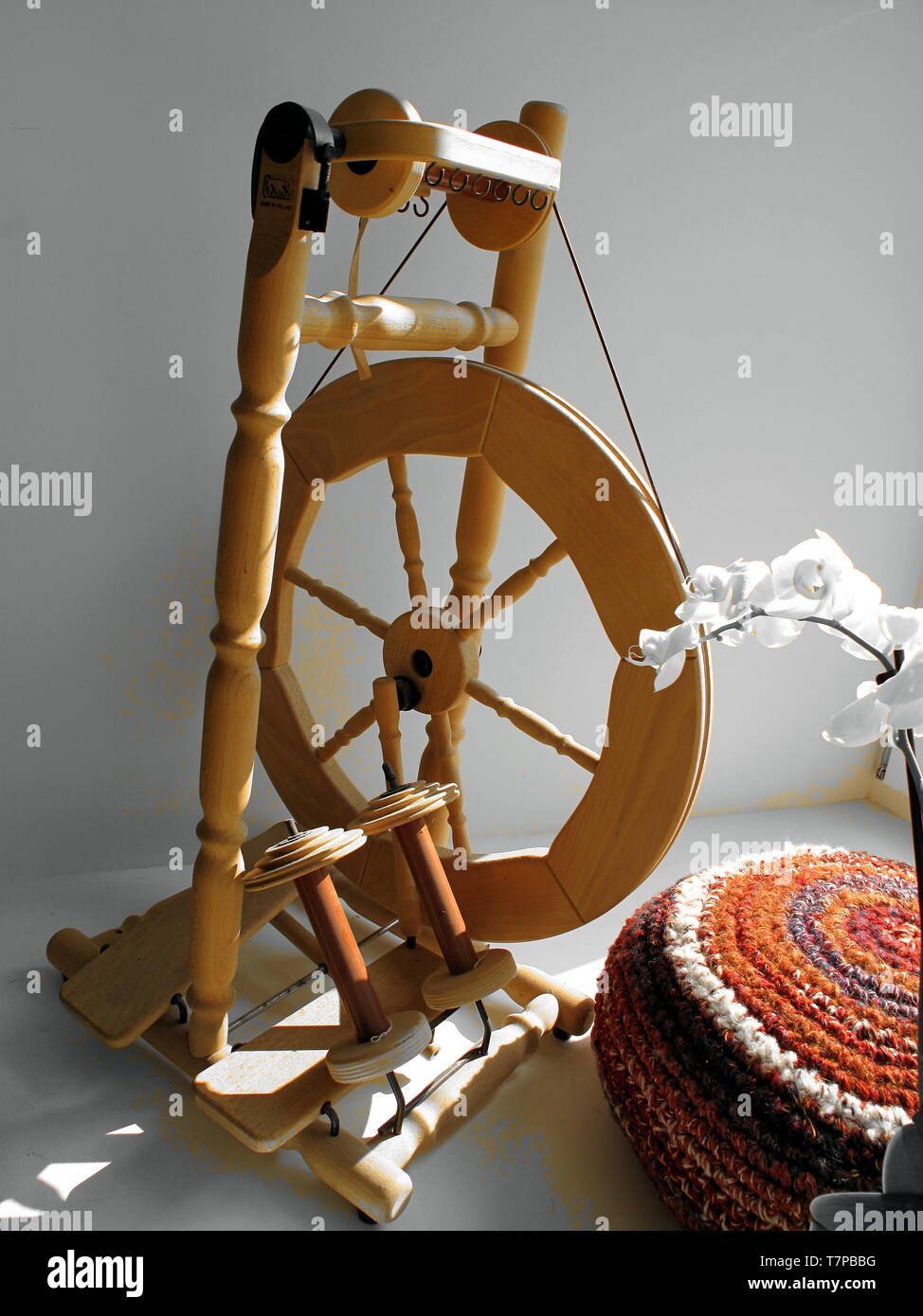 new spinning wheel next to crocheted cushions in window niche with a ...