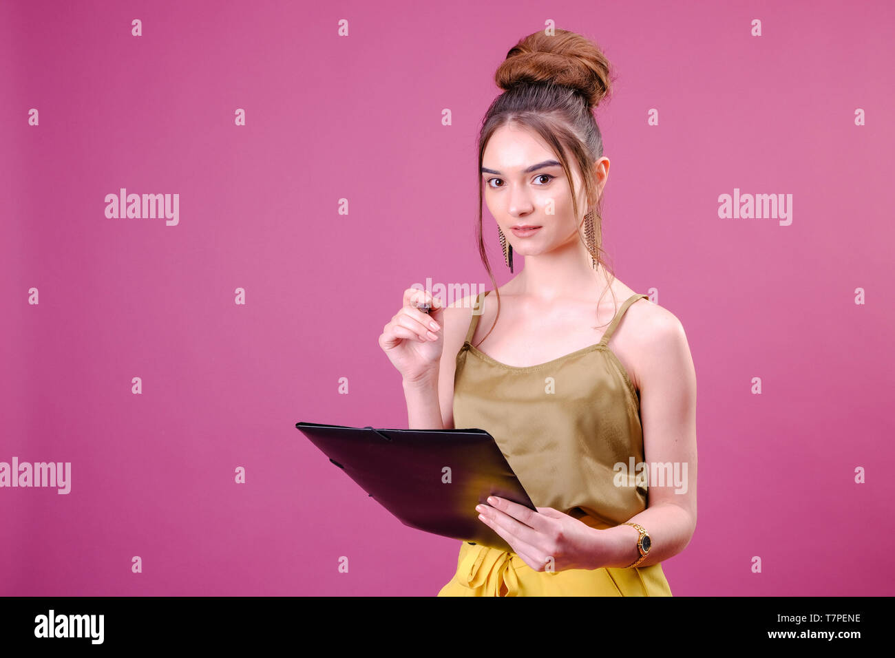 Pretty young beautiful woman standing, writing, take notes, holding ...