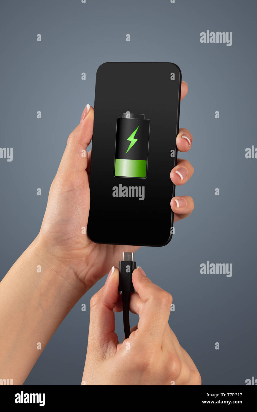 Elegant hand charging cellphone with low battery Stock Photo - Alamy