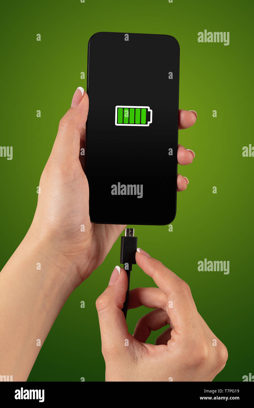 Elegant hand charging cellphone with low battery Stock Photo - Alamy