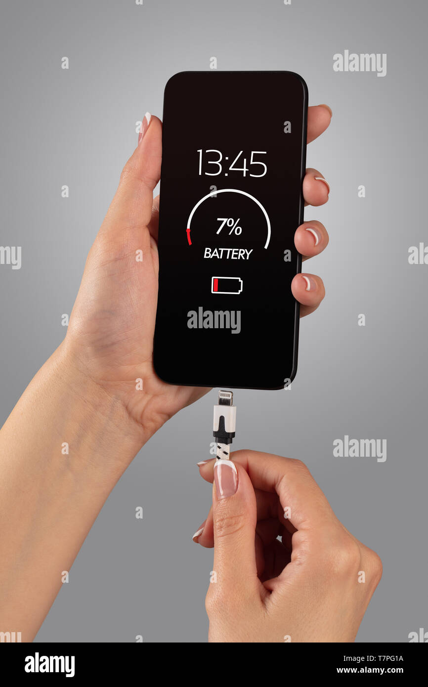 Elegant hand charging cellphone with low battery Stock Photo - Alamy