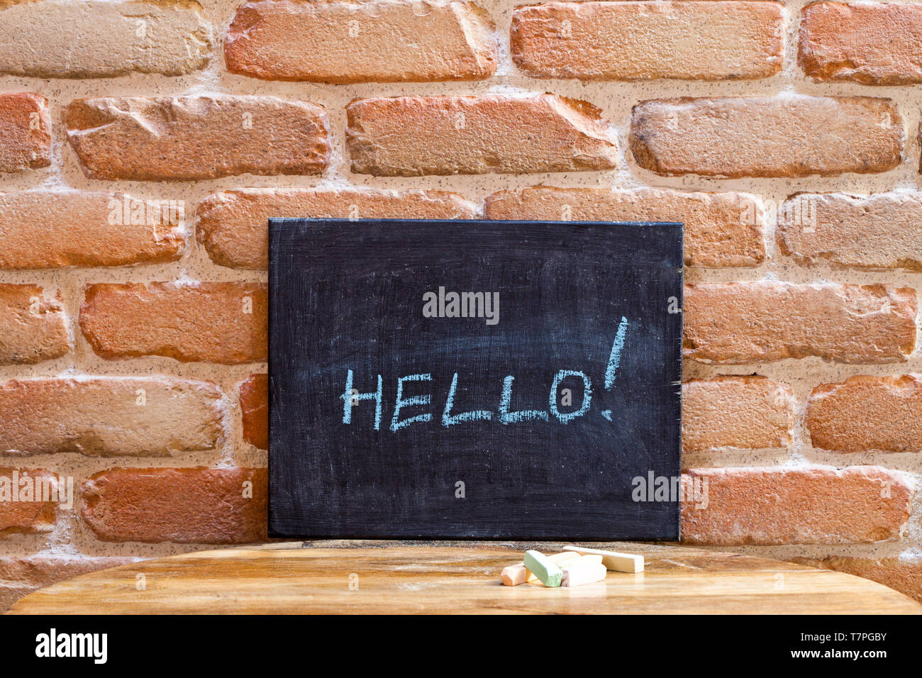 Black board with the word HELLO! drown by hand on wooden table on old ...