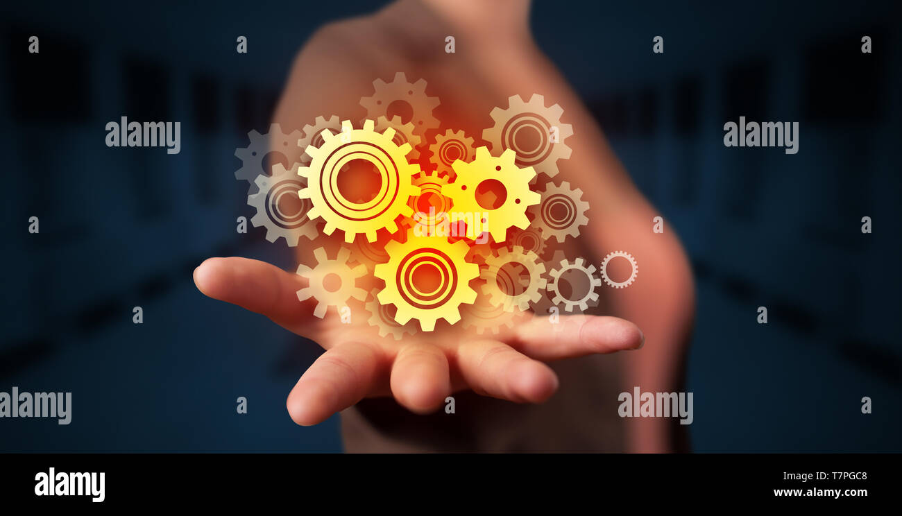 Hand holding gears in his hand Stock Photo - Alamy