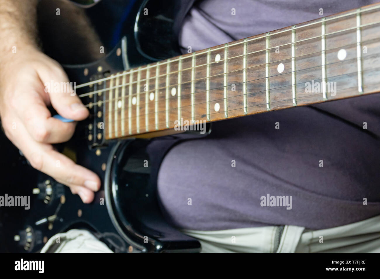 Close-up of man playing lead guitar solo on black guitar Stock Photo ...