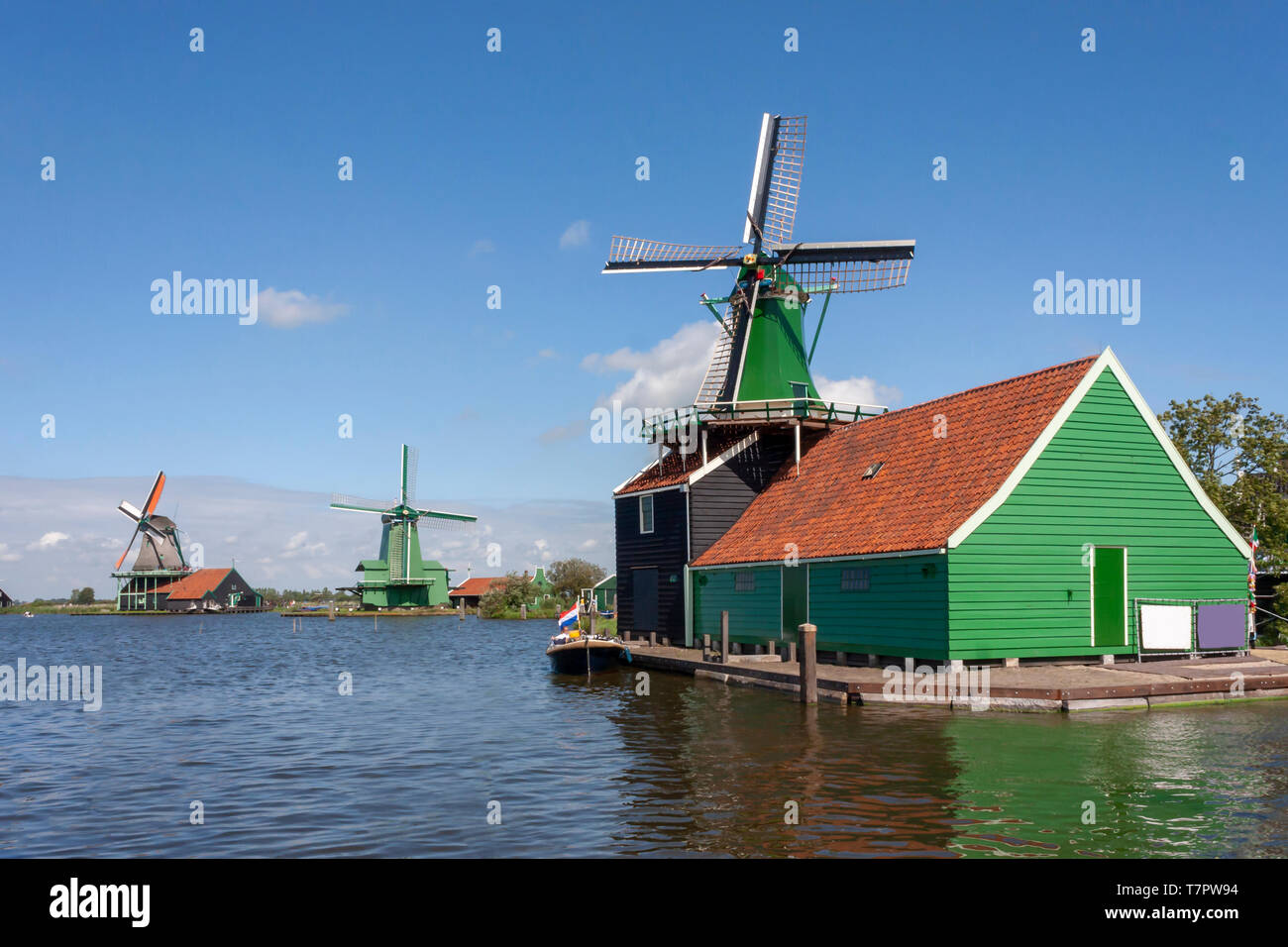 Dutch green sawmill at the edge of river facing the wind and reading ...