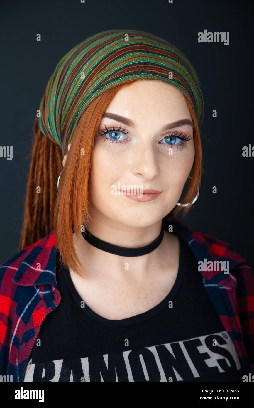 Portrait pf a beautiful red headed woman with dreadlocks and wearing a ...