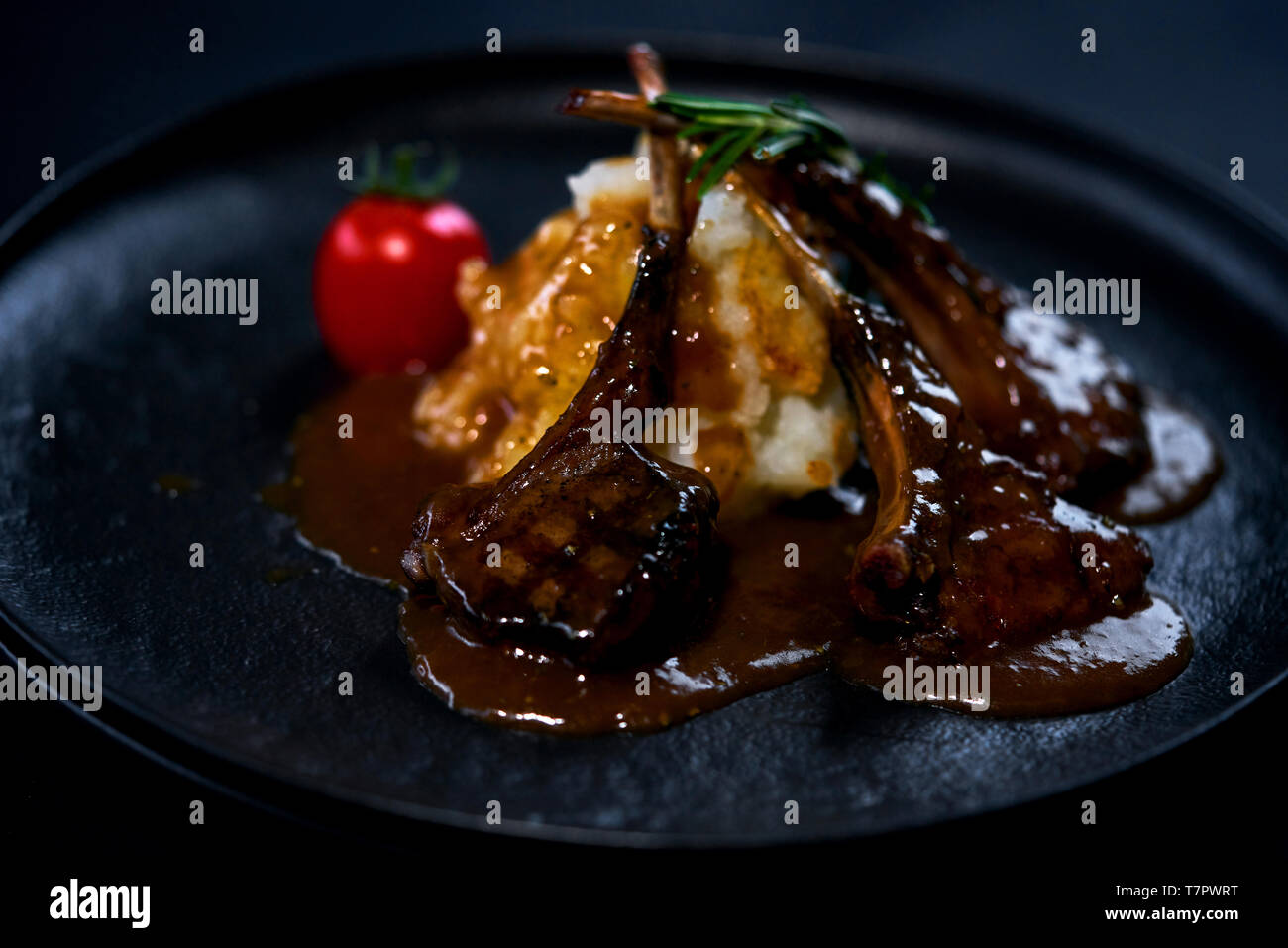 rack of lamb on a black plate with garnish Stock Photo - Alamy