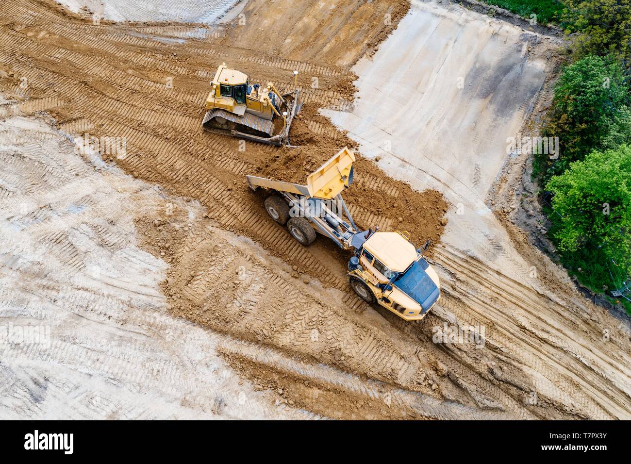Aerial drone view on bulldozer and dumper truck working on building ...