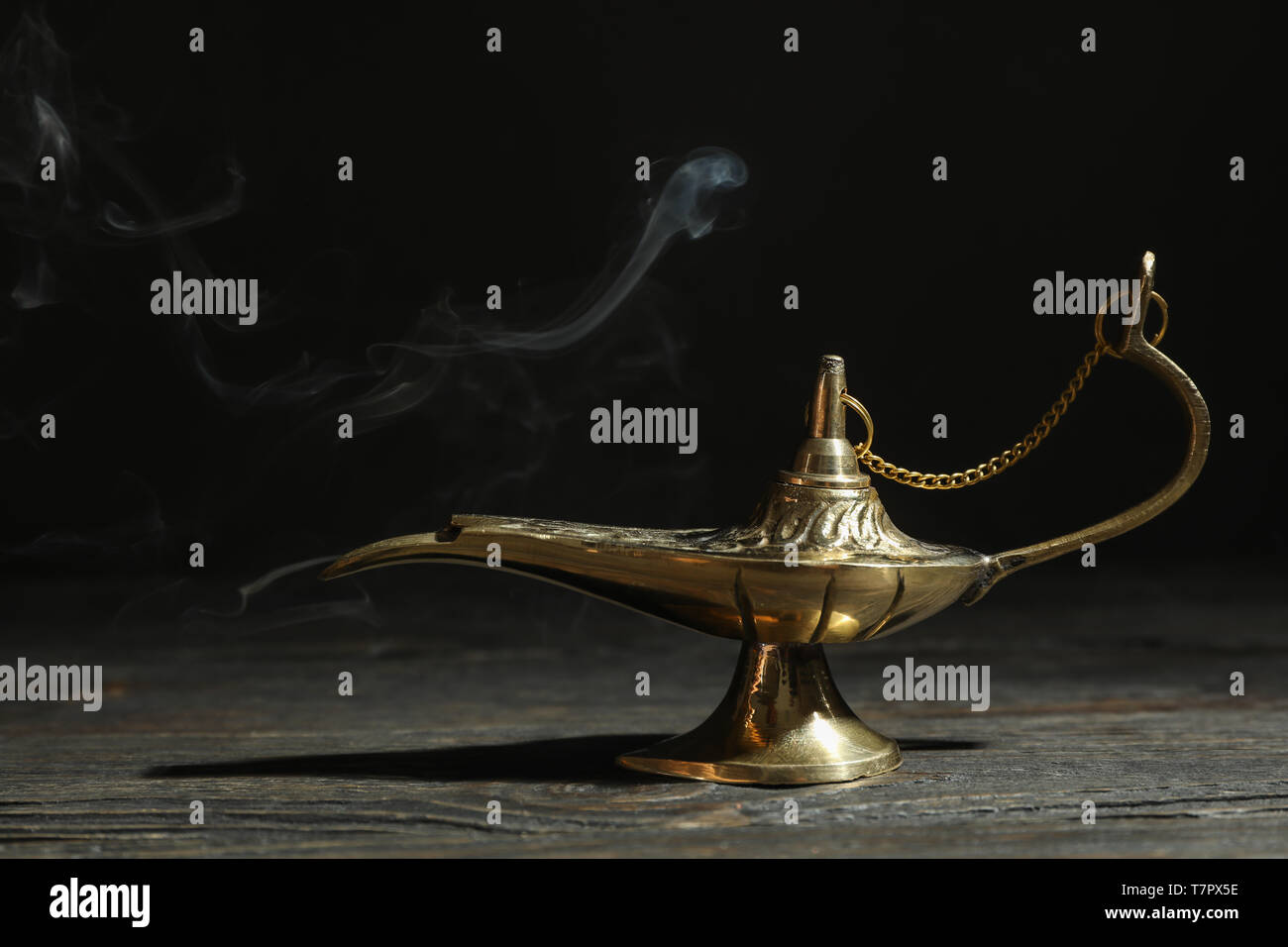 Magic Aladdin Lamp on wooden table against dark background Stock Photo ...
