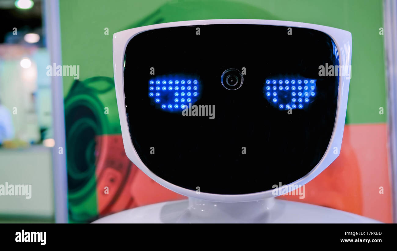 White sad robot with blue eyes at robotic show Stock Photo - Alamy