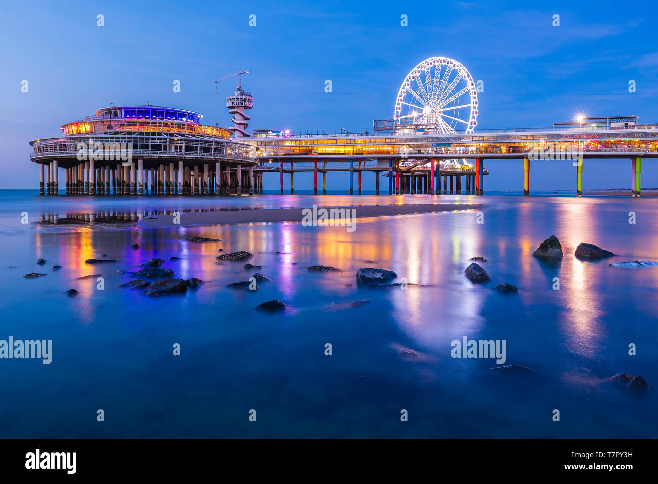 Colorful sunset on coastline, beach, pier and ferris wheel ...