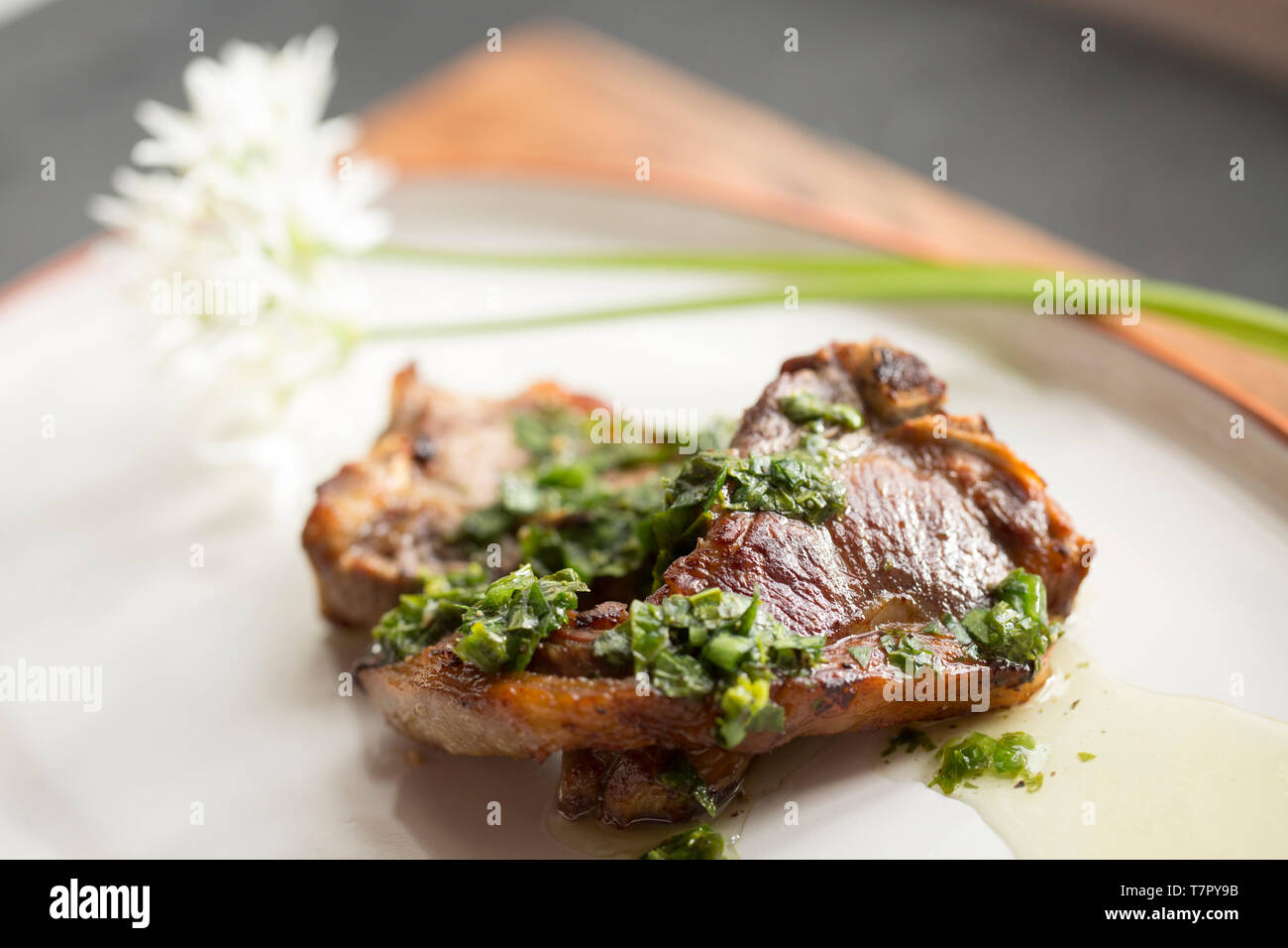 Two cooked British lamb chops bought from a supermarket that have been ...