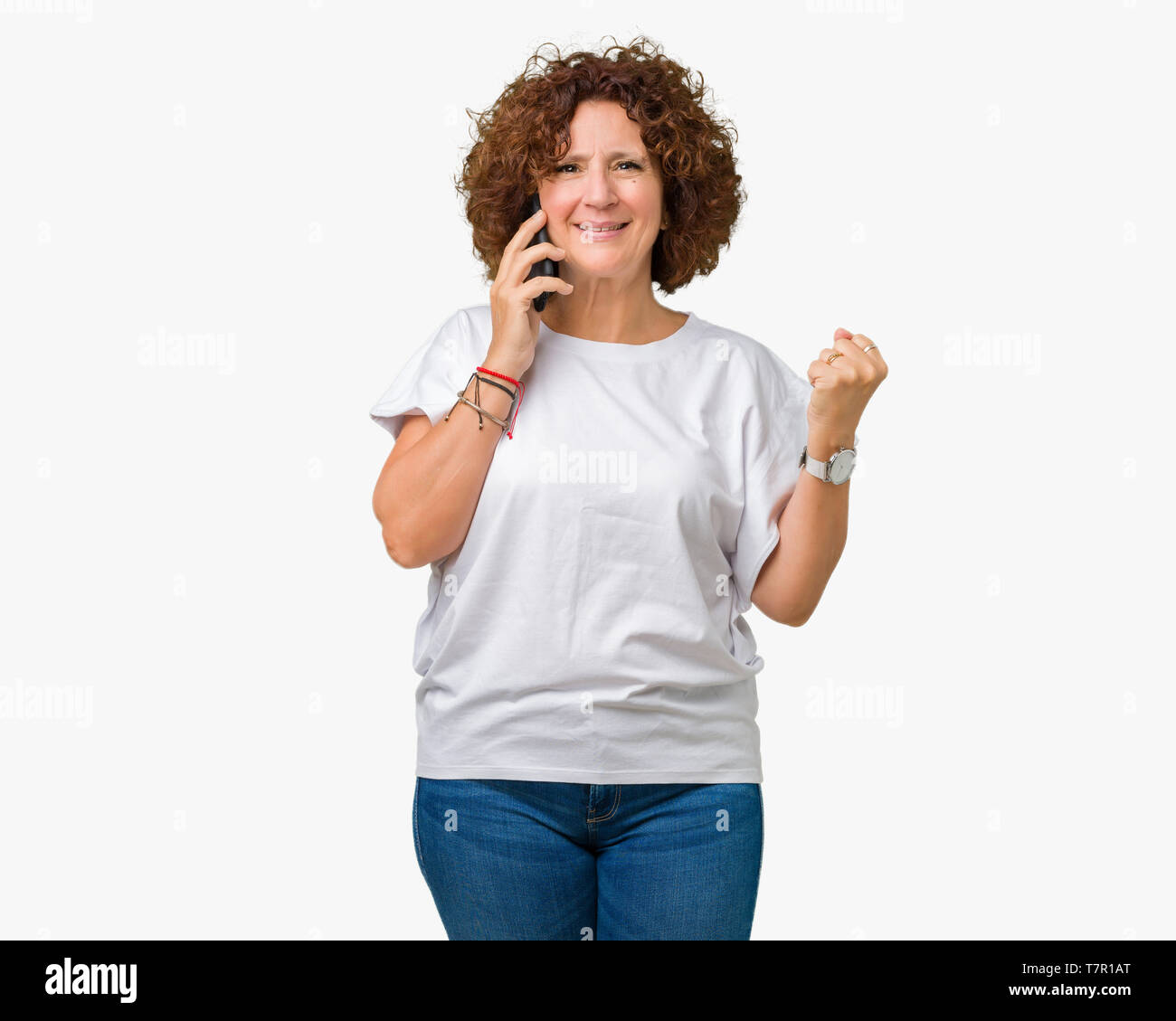 Middle ager senior woman talking on smartphone over isolated background ...