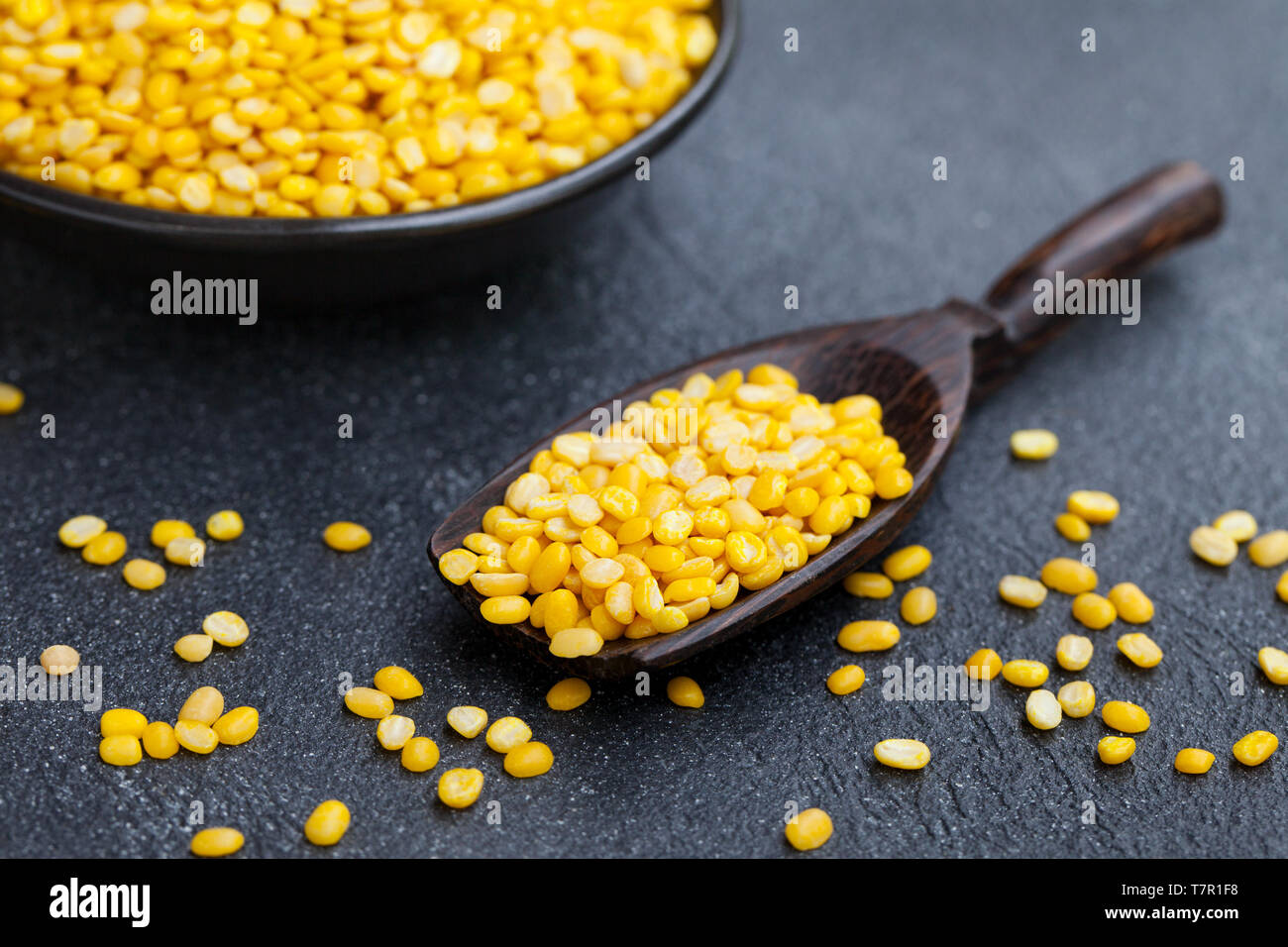 Yellow lentil in scoop and bowl. Dark slate background. Close up Stock ...