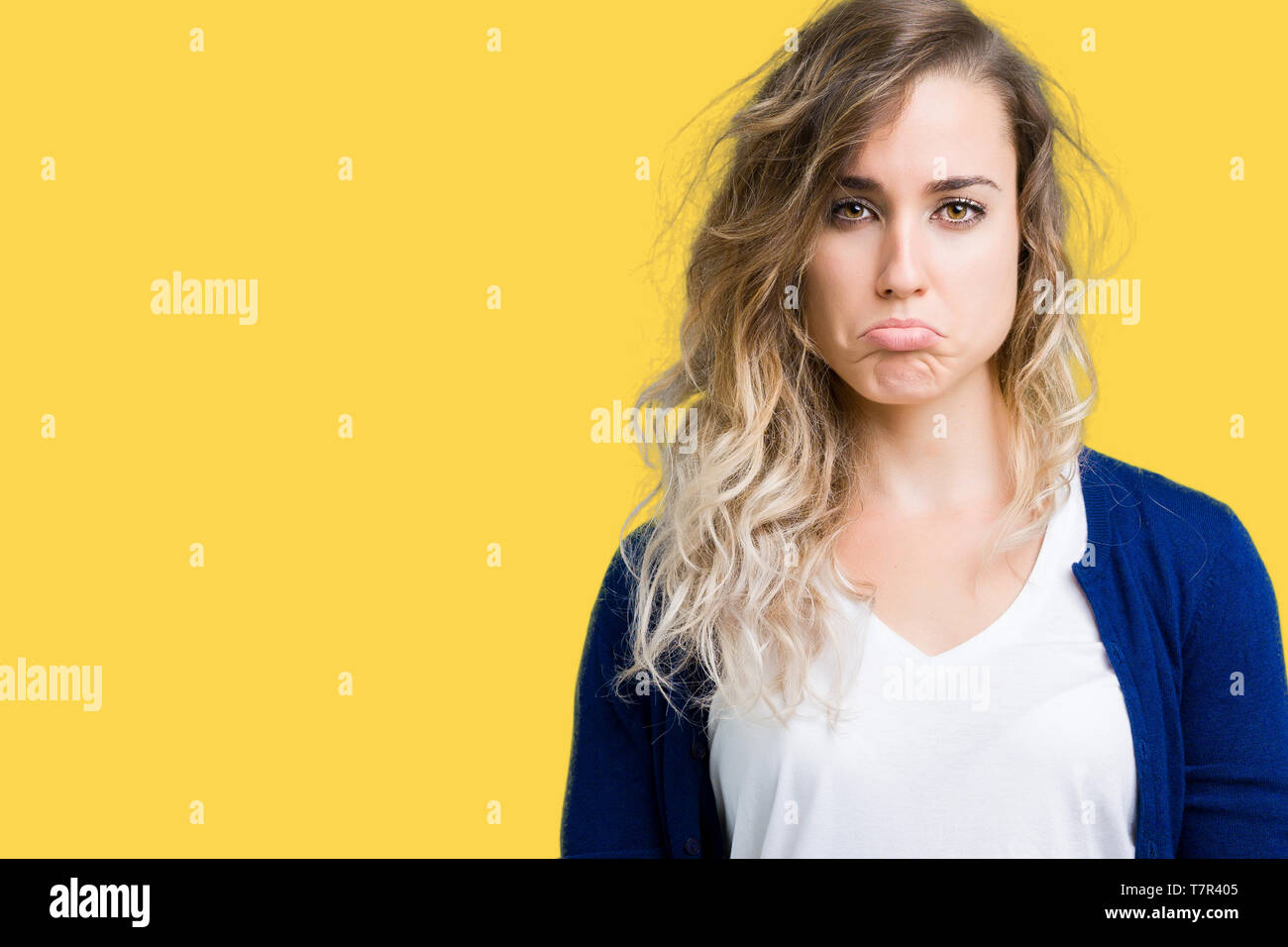 Beautiful young blonde woman over isolated background depressed and ...