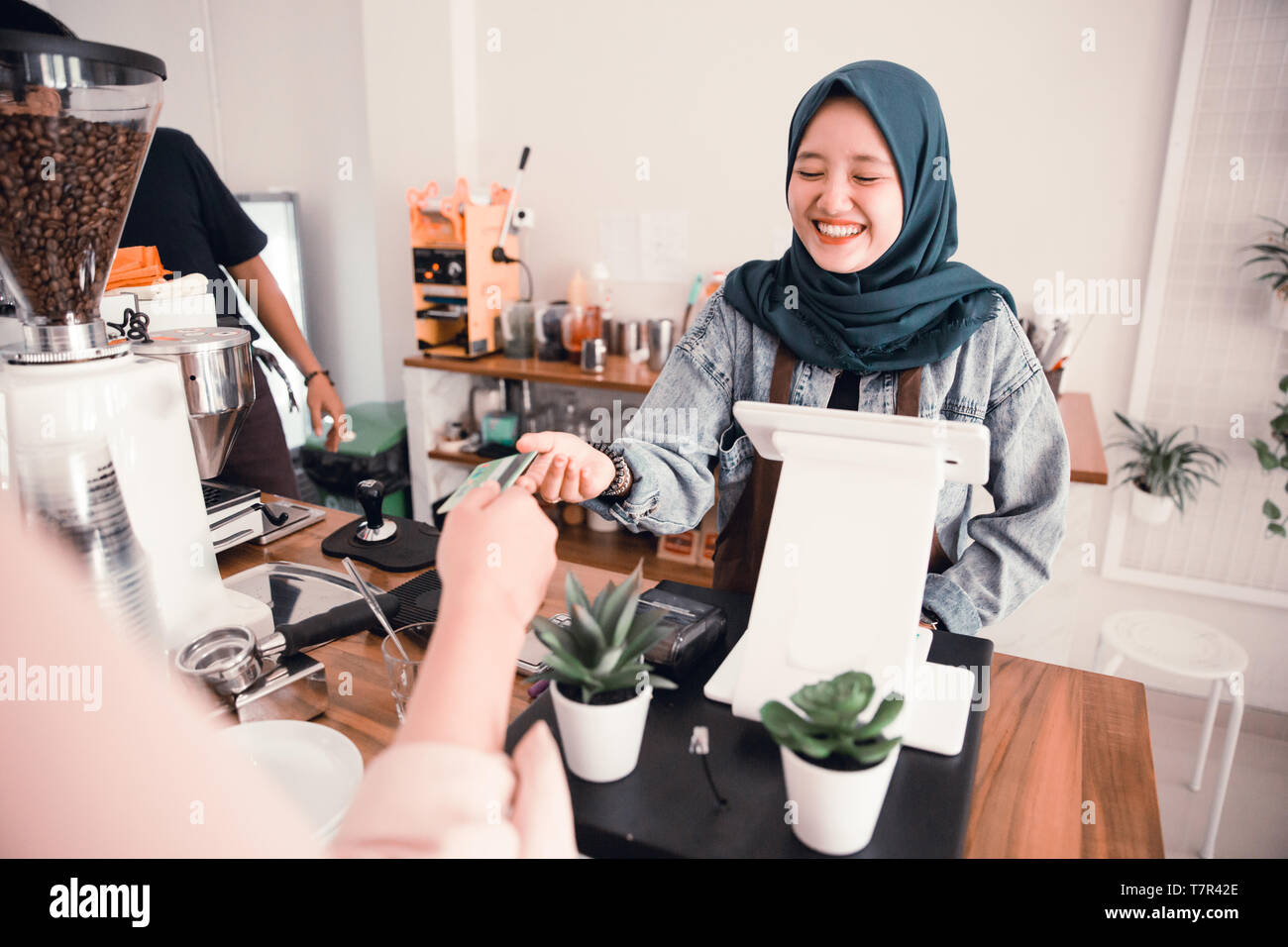 Young muslim cafe worker hi-res stock photography and images - Alamy
