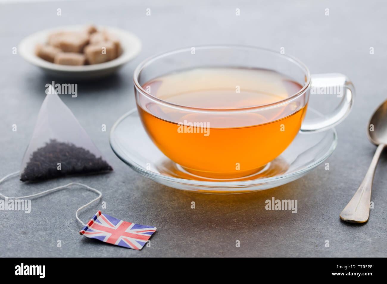 Tea cup with British flag tea bag label. Grey background. Close up ...