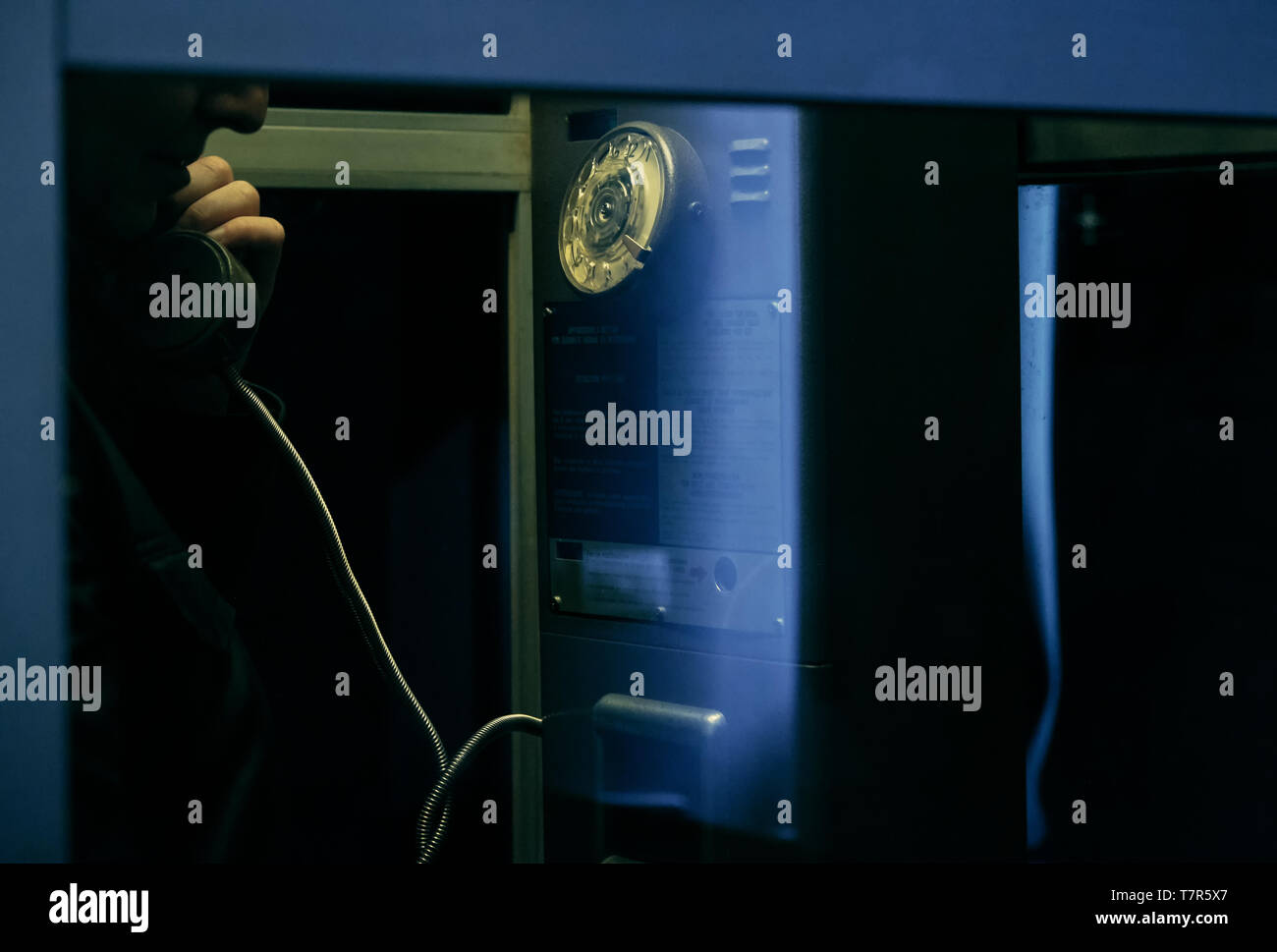 woman hand talking in a old vintage telephone cabin at night urban 80s ...
