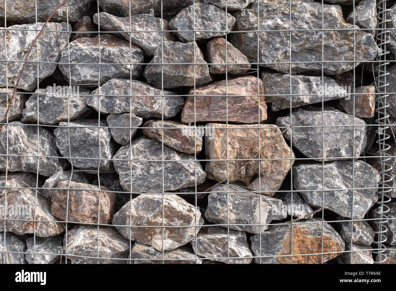 A close up of a pile of granite rocks in a metal cage used for flood ...