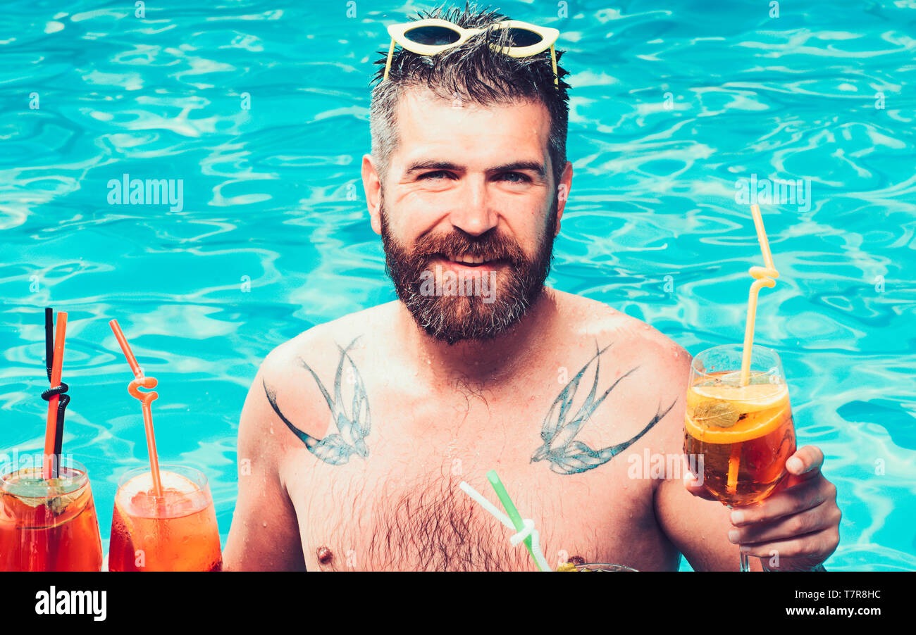 Man swimming and drink alcoholic beverage. Pool party with hipster in ...