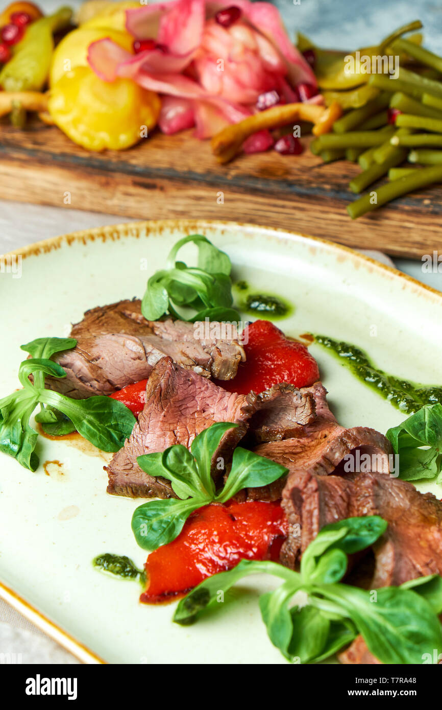 Carpaccio with sauce and spinach on a light plate. Beautiful serving ...