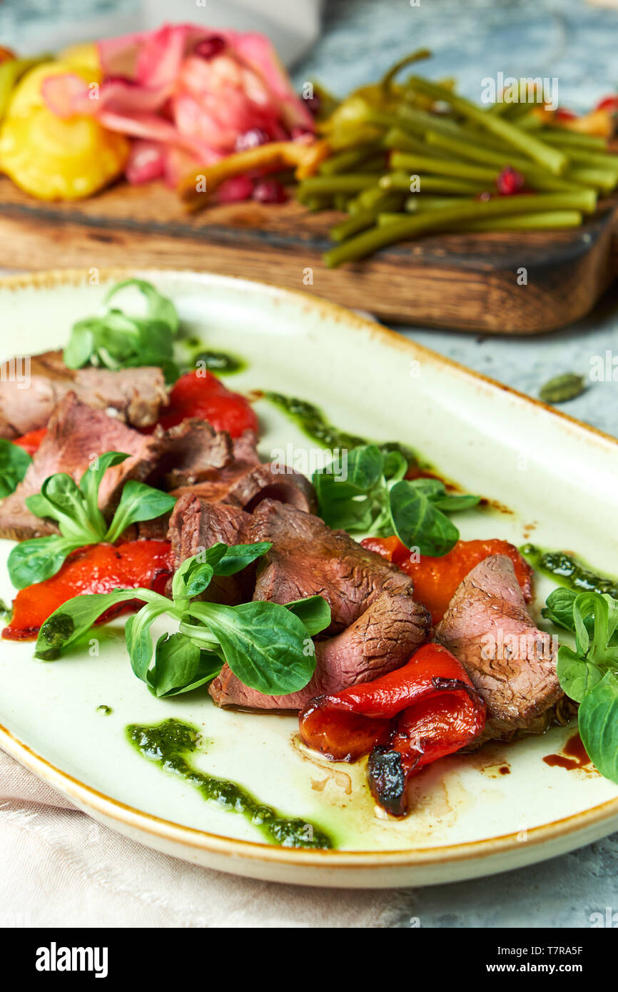 Carpaccio with sauce and spinach on a light plate. Beautiful serving ...
