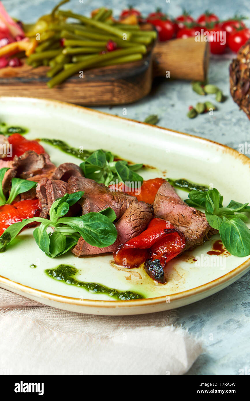 Carpaccio with sauce and spinach on a light plate. Beautiful serving ...