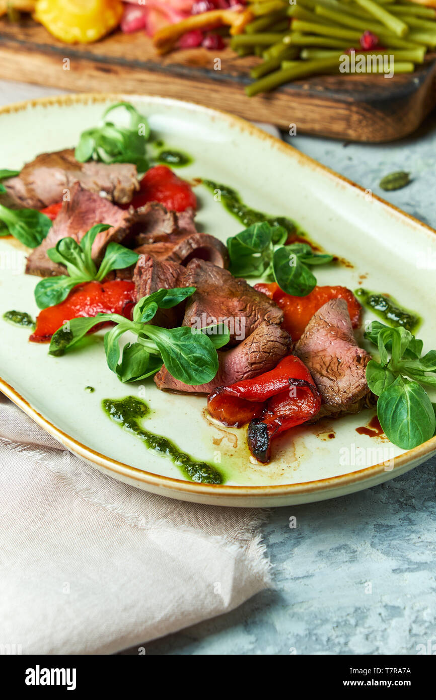 Carpaccio with sauce and spinach on a light plate. Beautiful serving ...