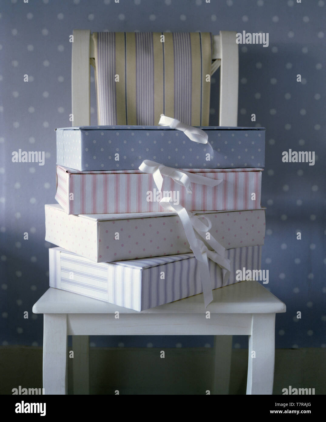 Fabric covered storage boxes on white chair Stock Photo - Alamy
