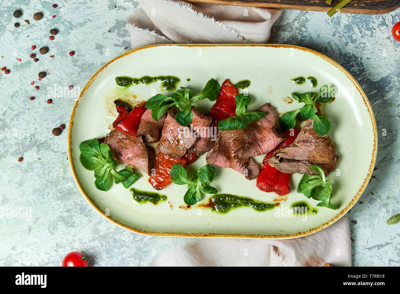 Carpaccio with sauce and spinach on a light plate. Beautiful serving ...