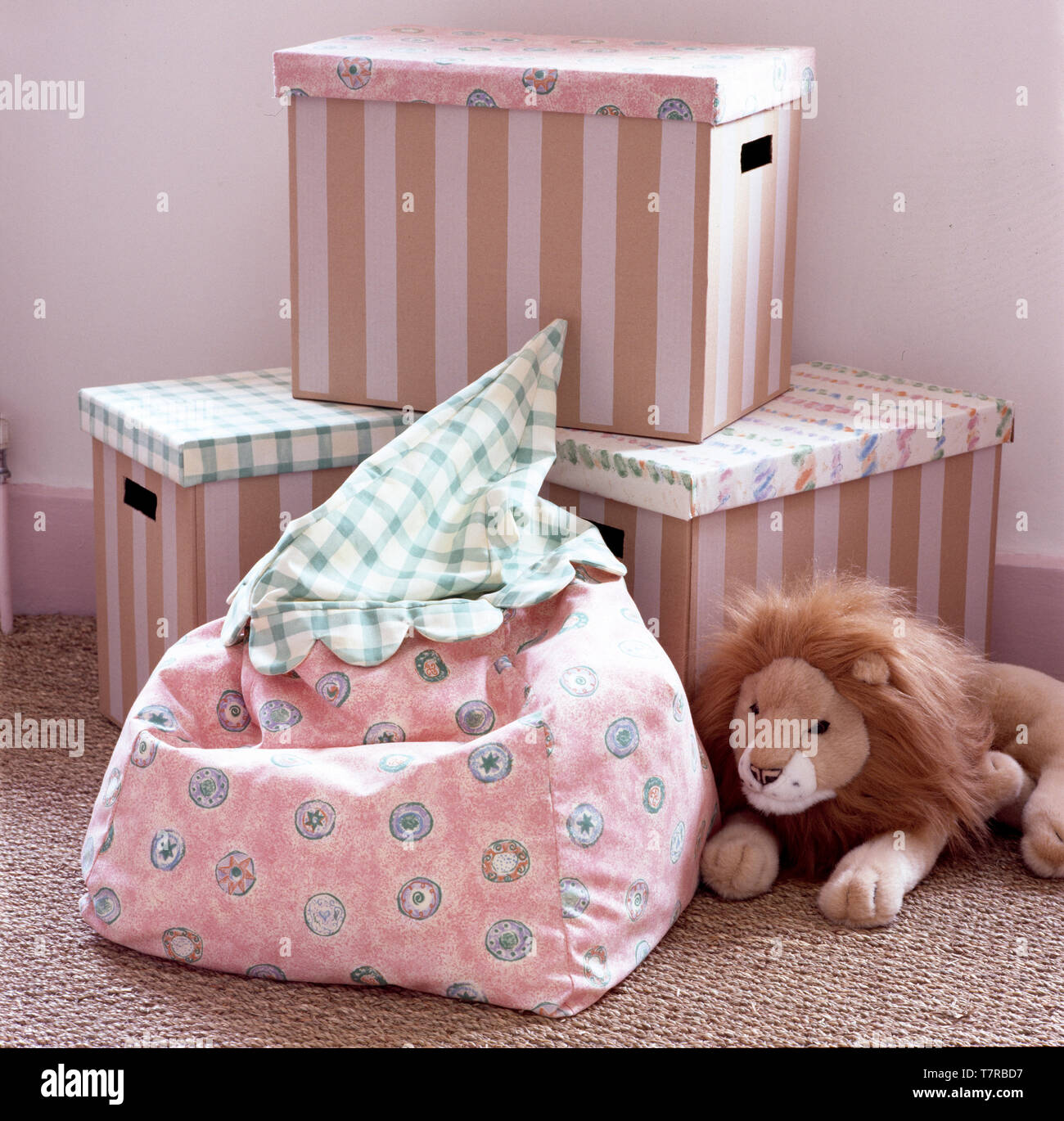 Child's bean bag and toy lion with striped storage boxes Stock Photo ...