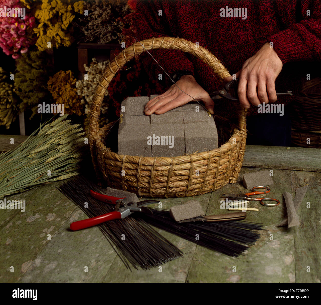 Hands placing oasis block in floral display basket Stock Photo - Alamy