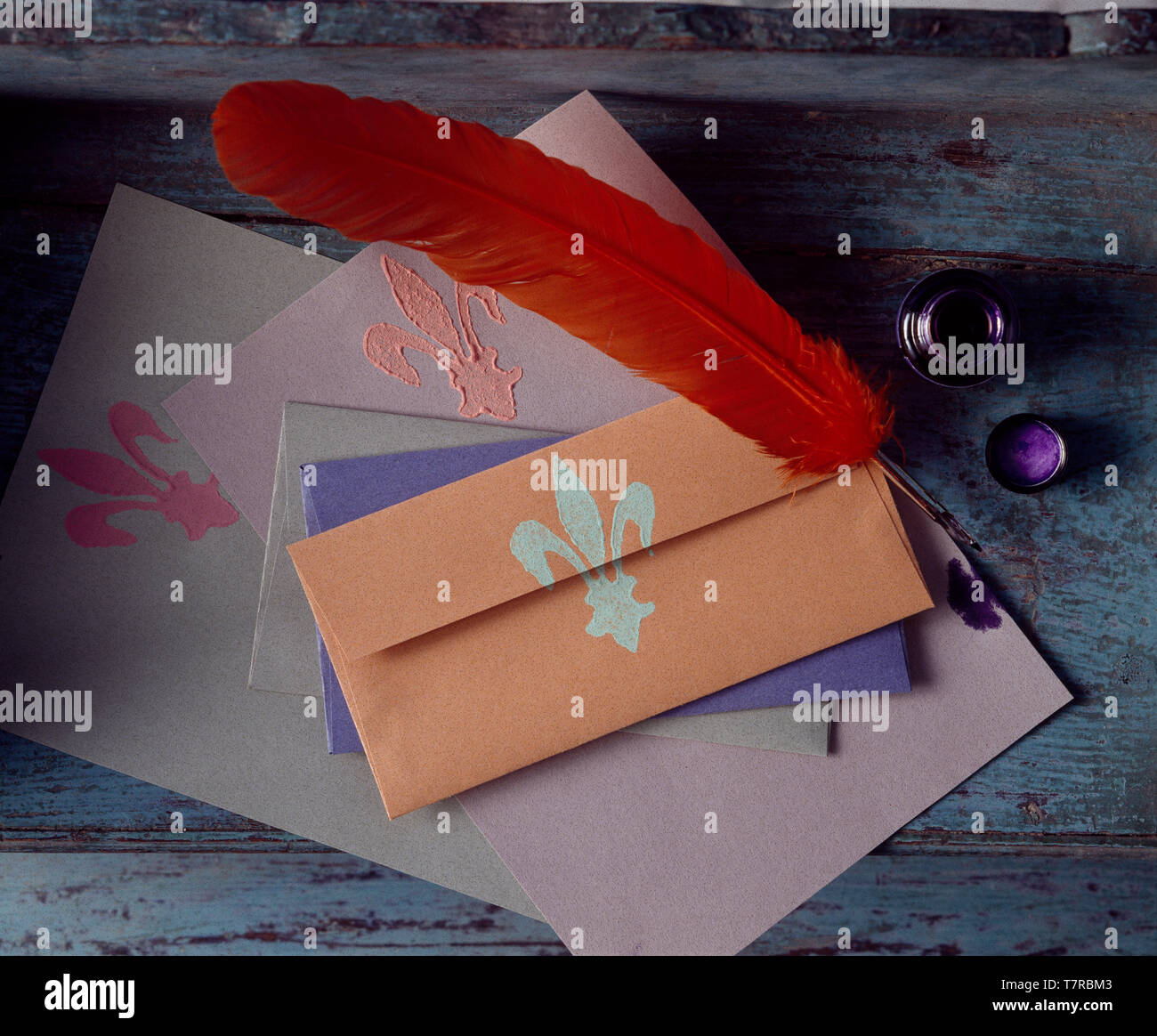 Red quill pen with Fleur de Lis envelope and writing paper Stock Photo ...