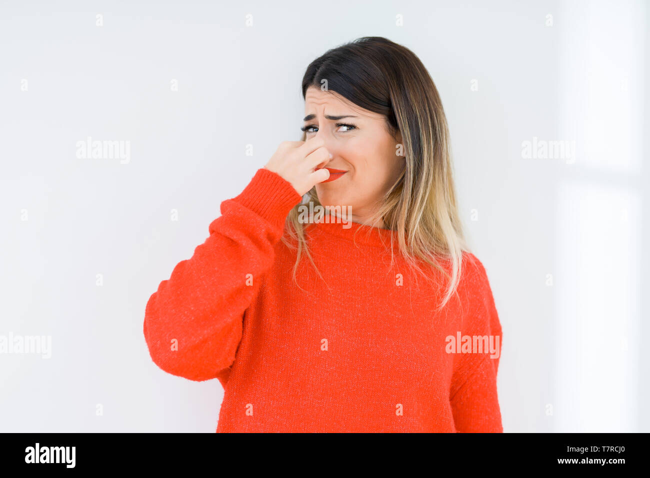 Young woman wearing casual red sweater over isolated background ...