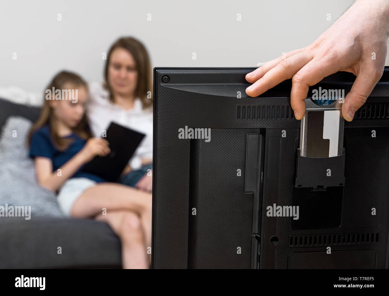 Man installing conditional access module card to TV Stock Photo - Alamy