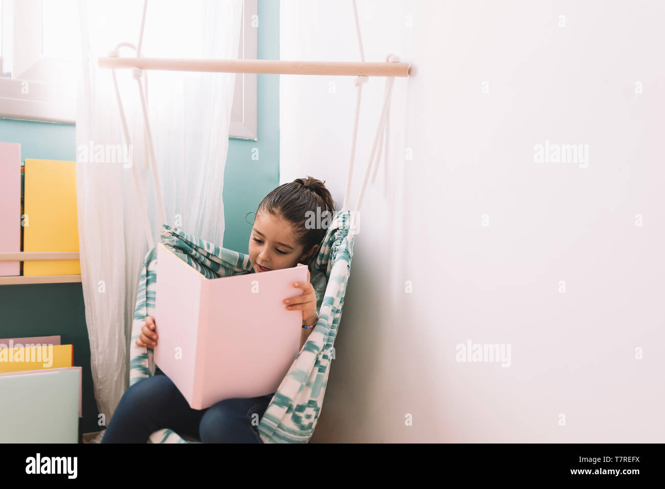 cute little kid girl is reading a book at home. funny lovely child ...