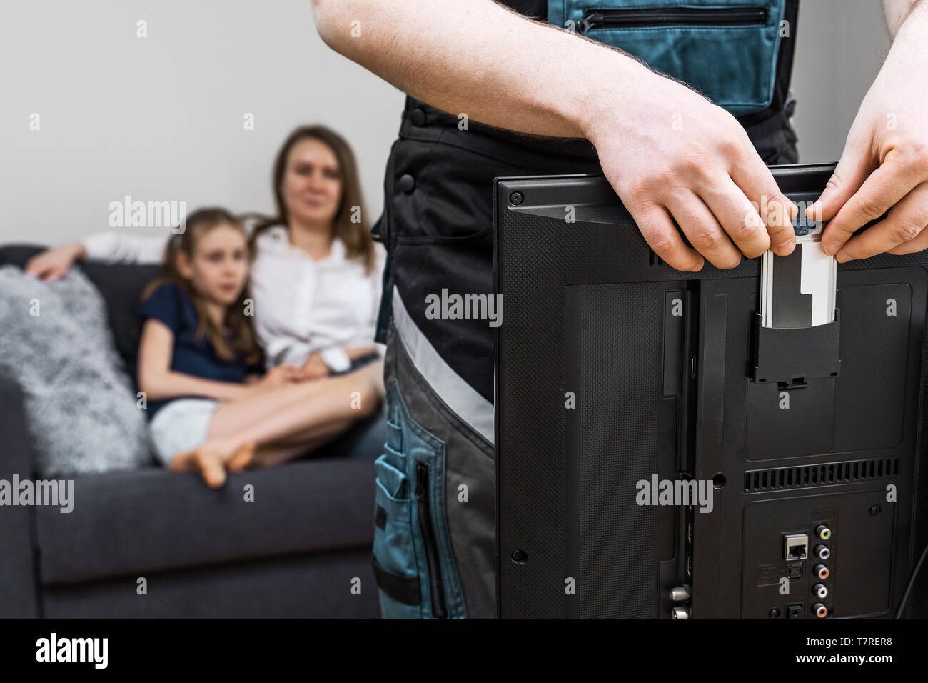 Man installing conditional access module card to TV Stock Photo - Alamy