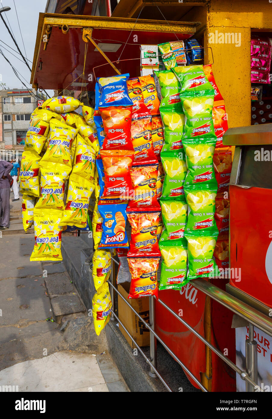 Display of colourful crisp packets hung upside down outside a roadside ...