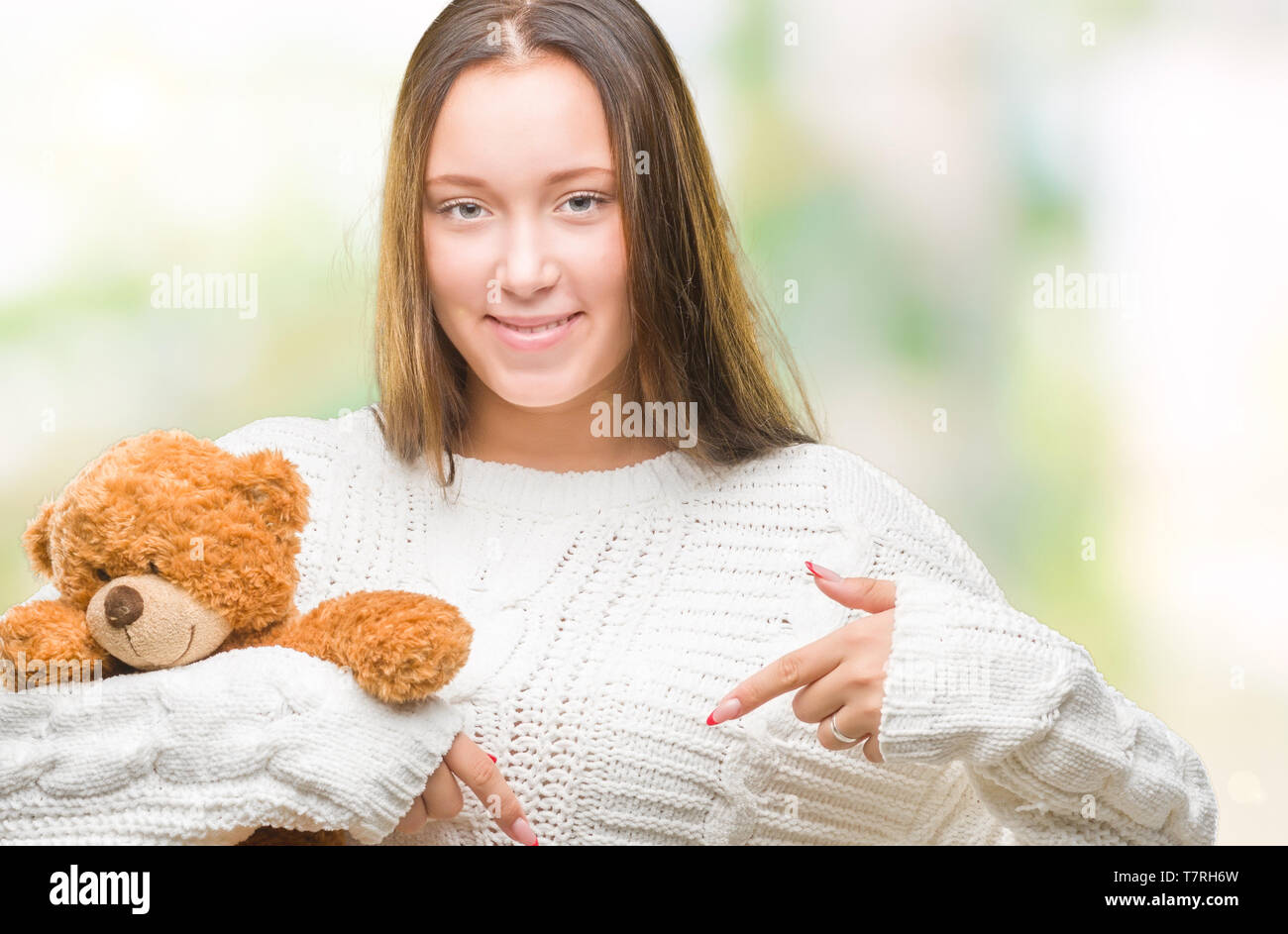 Young caucasian woman holding teddy bear over isolated background with ...