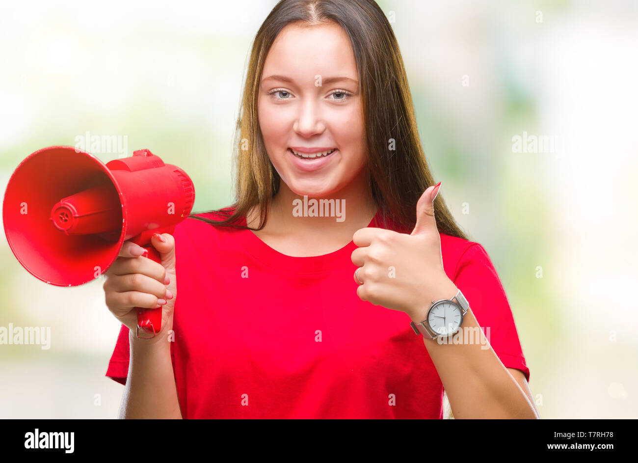 Young caucasian woman yelling through megaphone over isolated ...